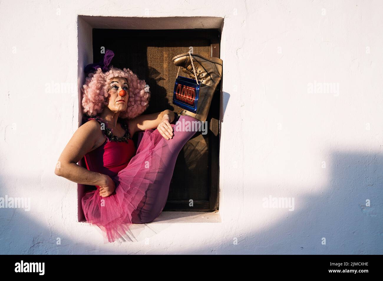 Side view of eccentric middle aged female clown in funny costume and ...