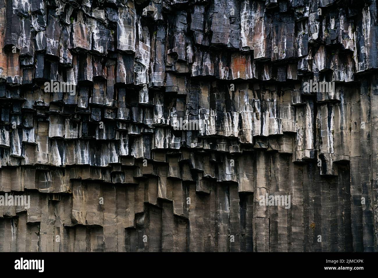 Rocky textured columns of massive basalt cliff located in Iceland as ...
