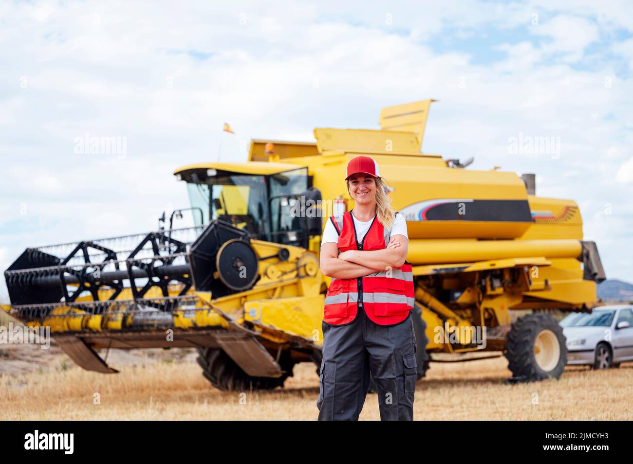 Positive female worker in uniform looking at camera while standing in ...