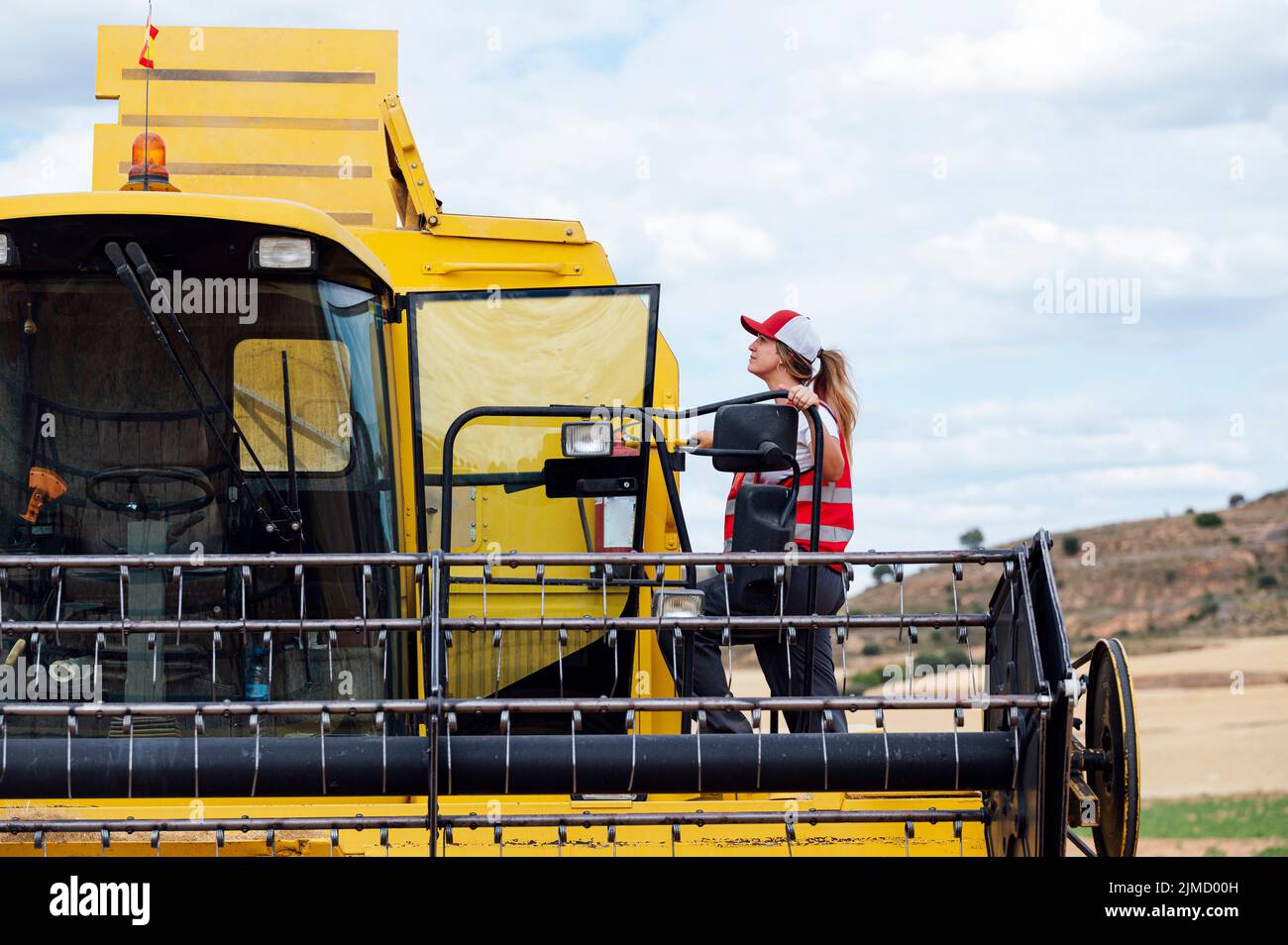 Full body side view of female worker in uniform getting into industrial ...