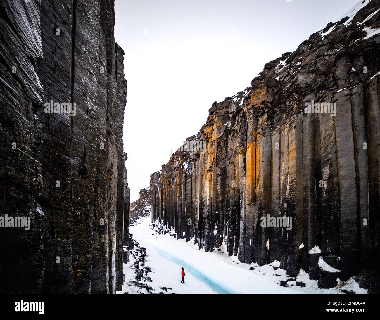 Unrecognizable traveler walking in between spectacular scenery of rocky ...