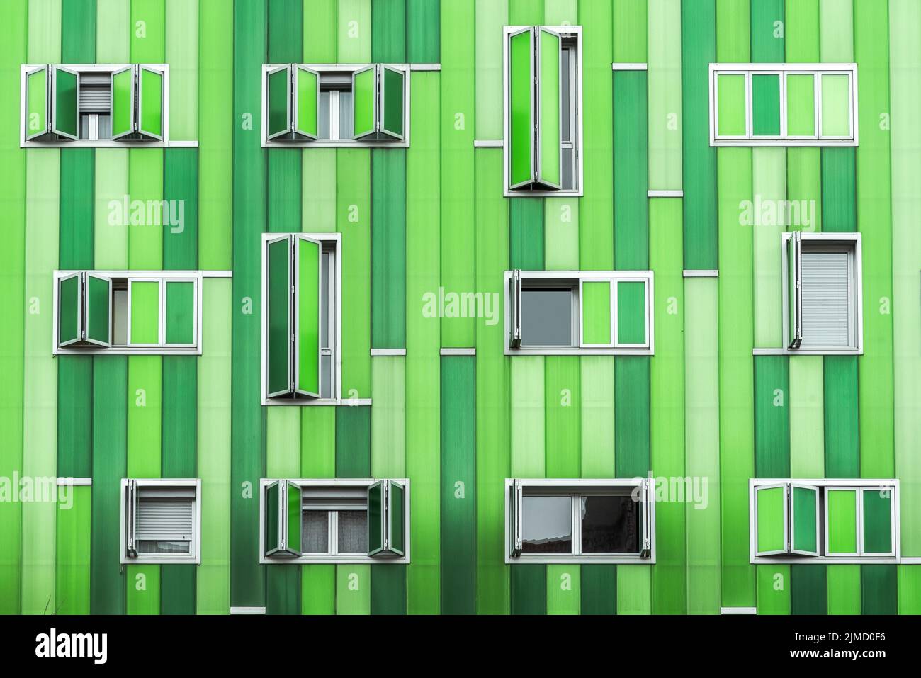 Contemporary building with vivid green facade and opened windows Stock ...