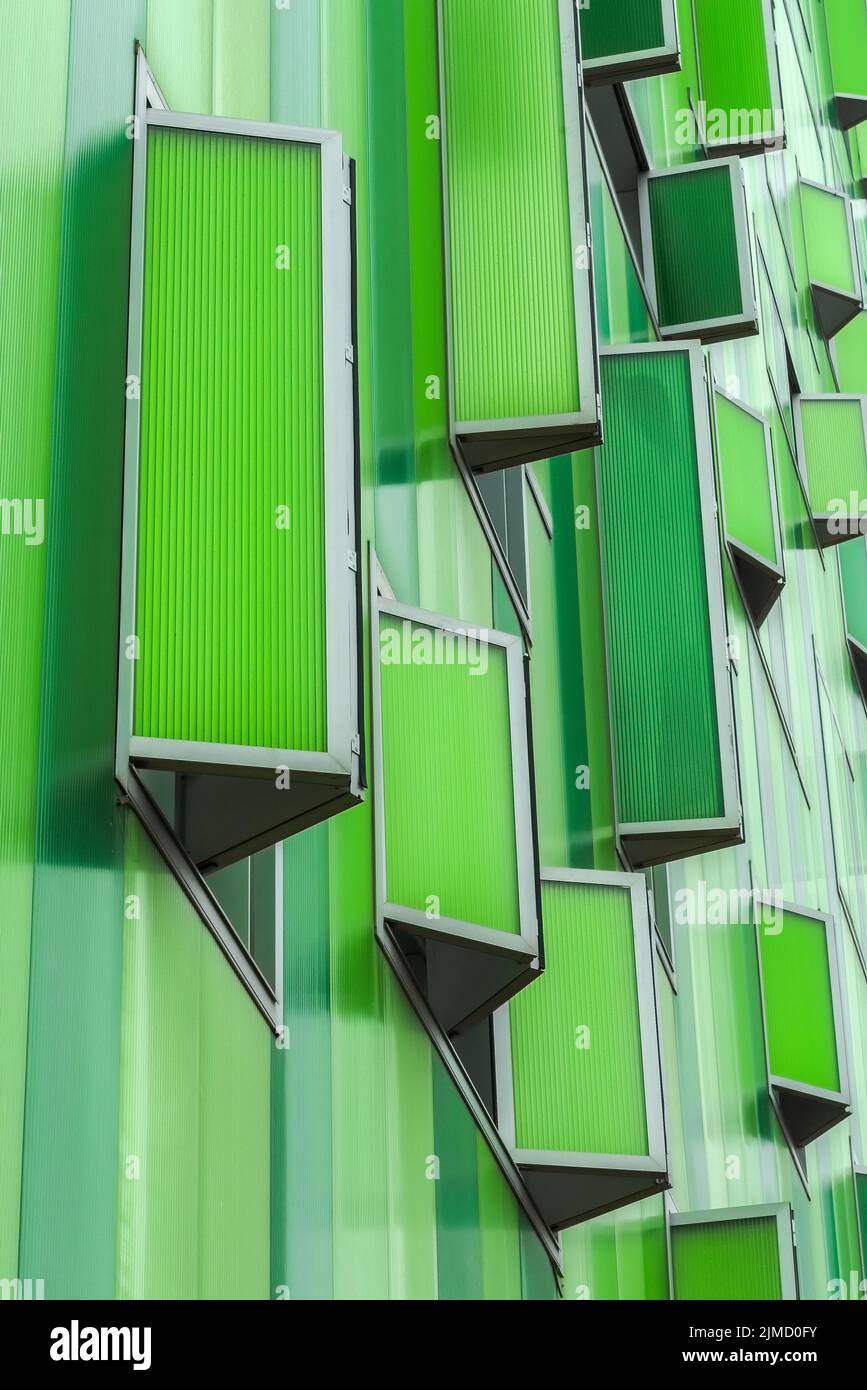 Contemporary building with vivid green facade and opened windows Stock ...