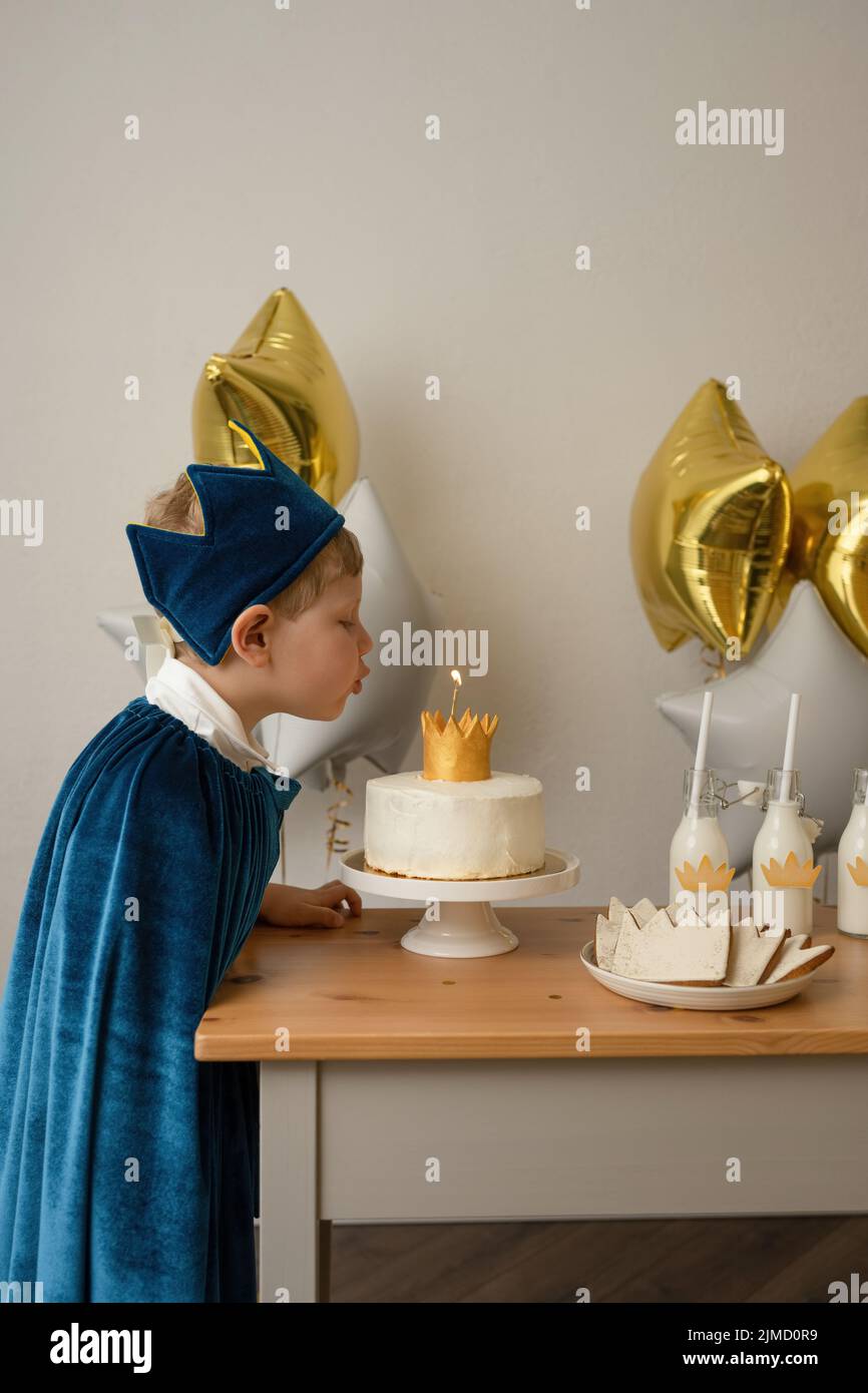 Side view blond boy blowing out candles at a birthday party Stock Photo ...