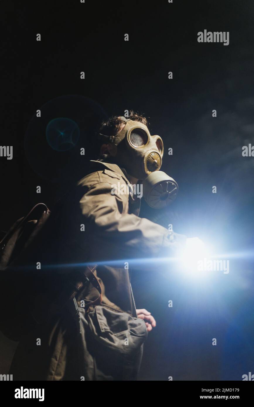 From below side view of unrecognizable male explorer in gas mask ...