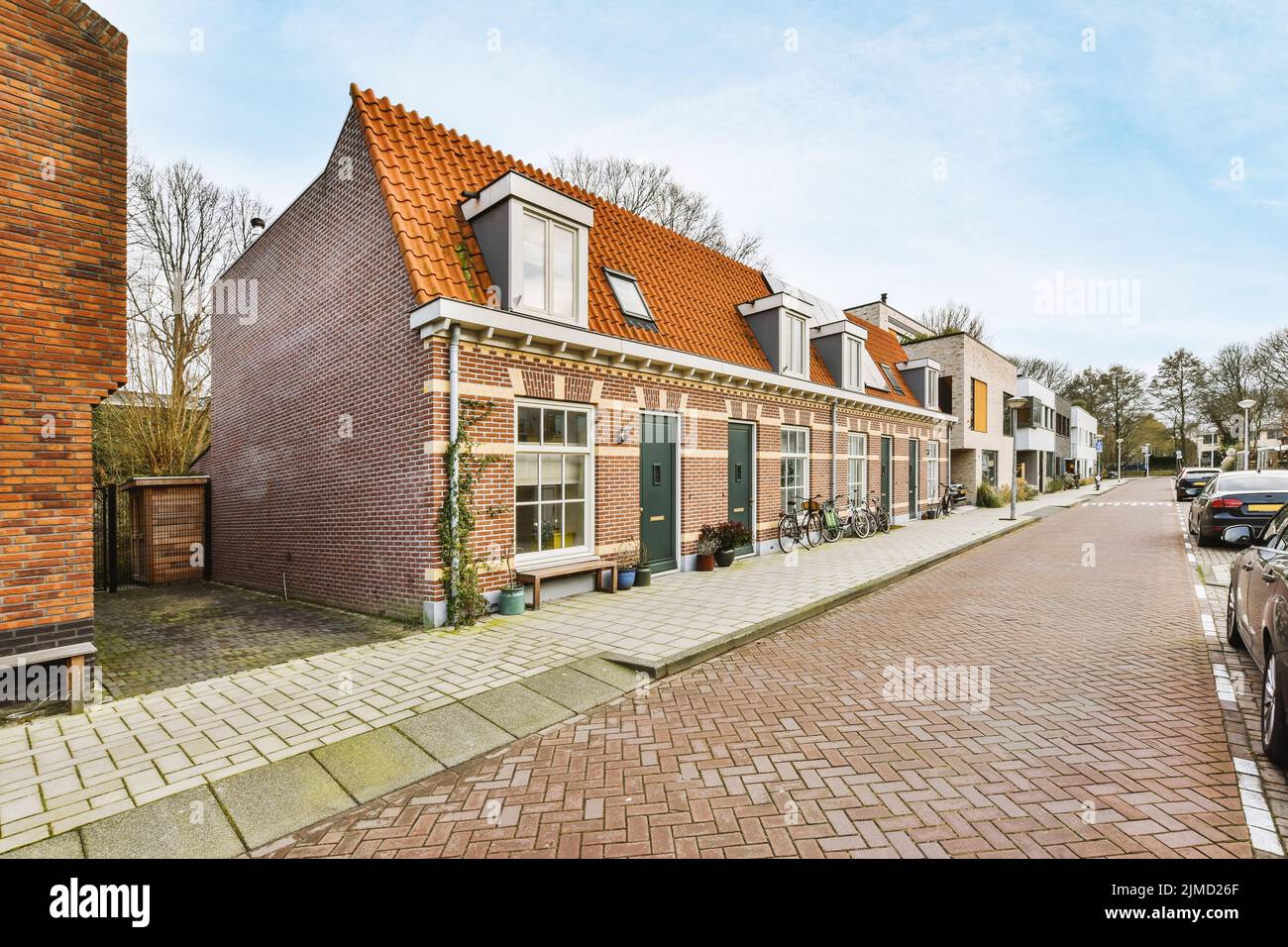 View of a street with houses lined up next to cars parked on the ...