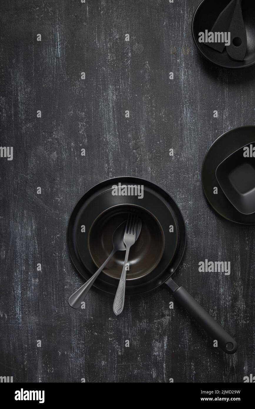 Dinner served table with black cookware on the same color background ...