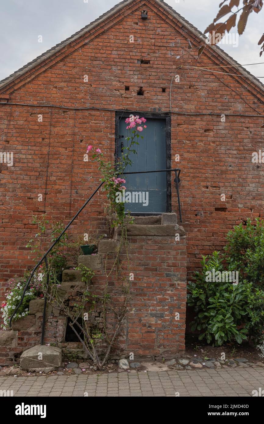A set of delapidated stone steps leding upwards towards a blue door in ...