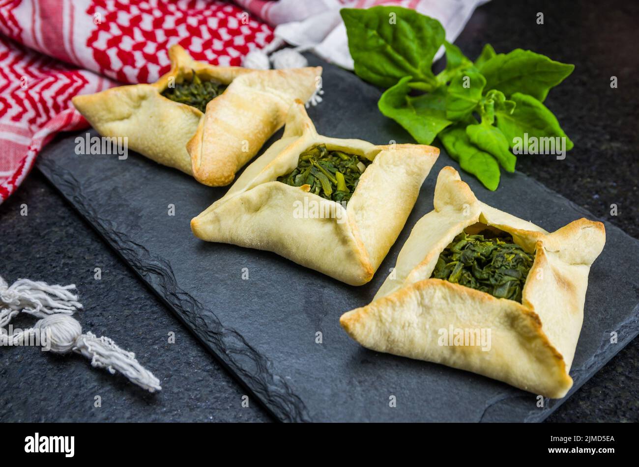 Delicious Lebanese food, spinach sfiha on black slate stone background ...