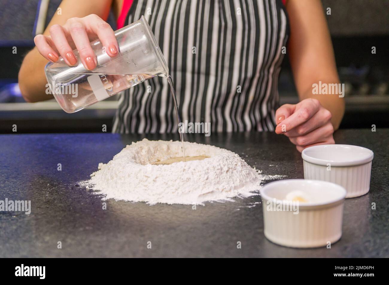 Woman preparing pizza dough on black granite table Stock Photo - Alamy