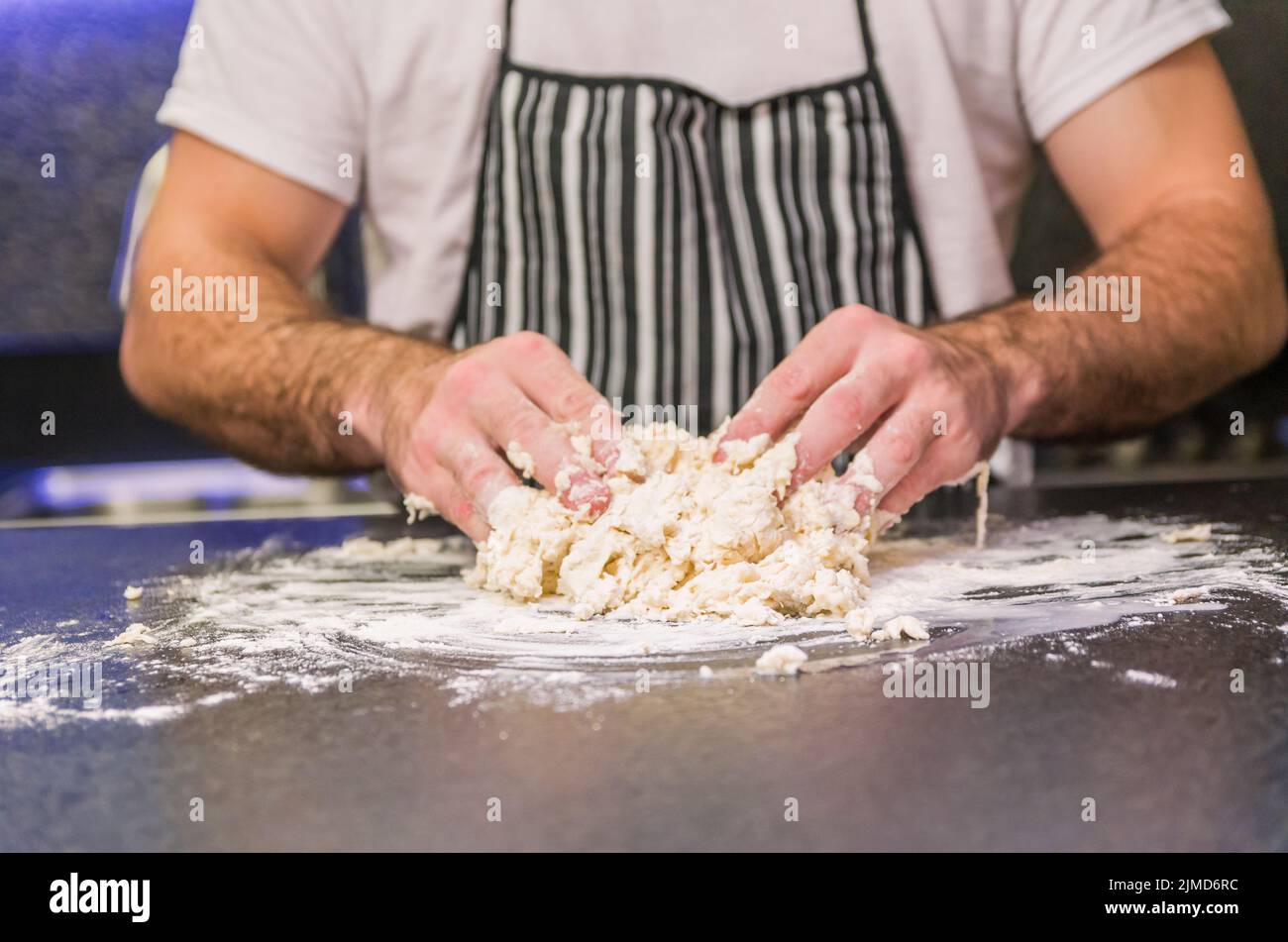 Man preparing pizza dough on black granite table Stock Photo - Alamy