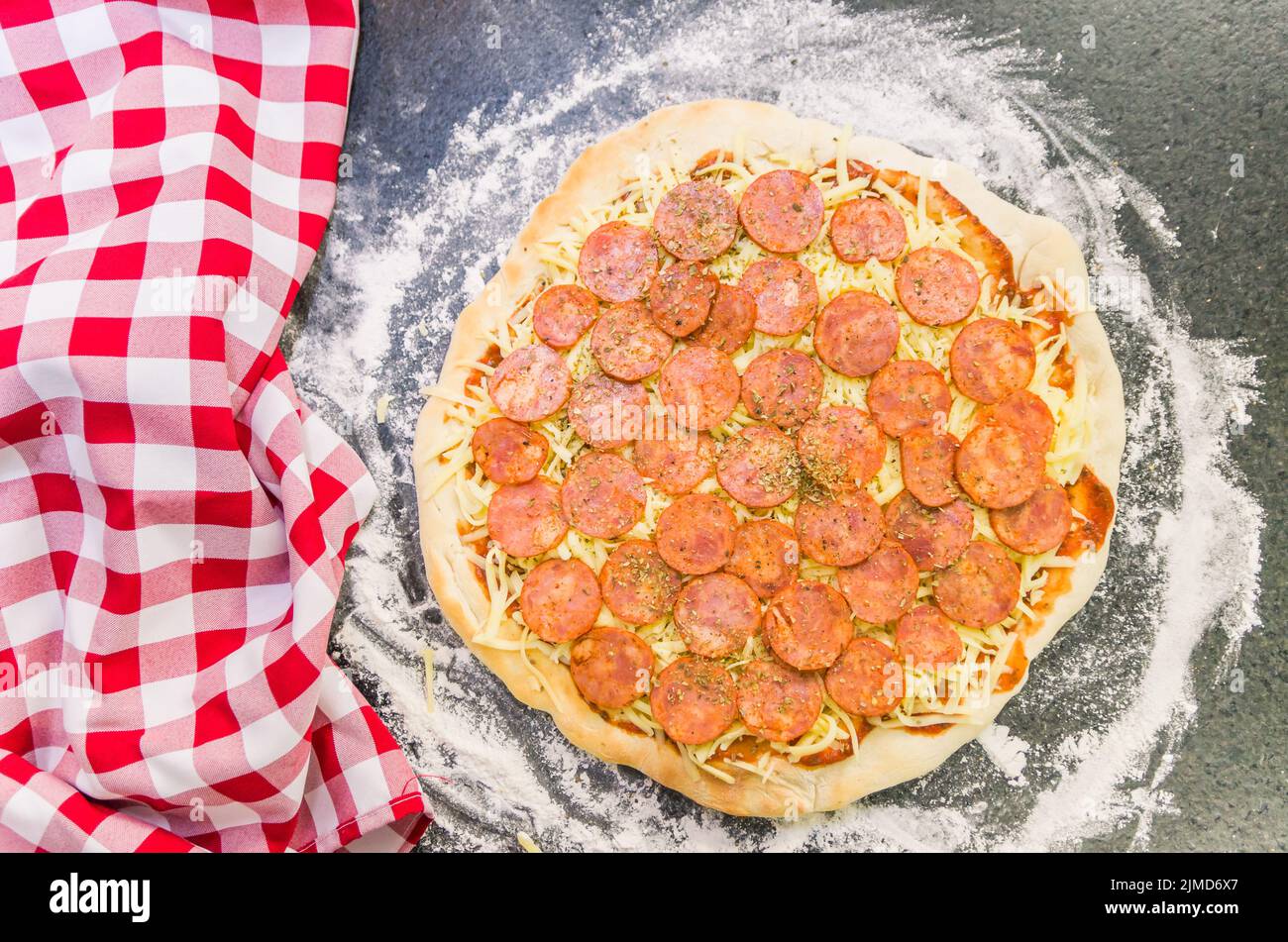 Preparing pepperoni pizza on black granite table Stock Photo - Alamy