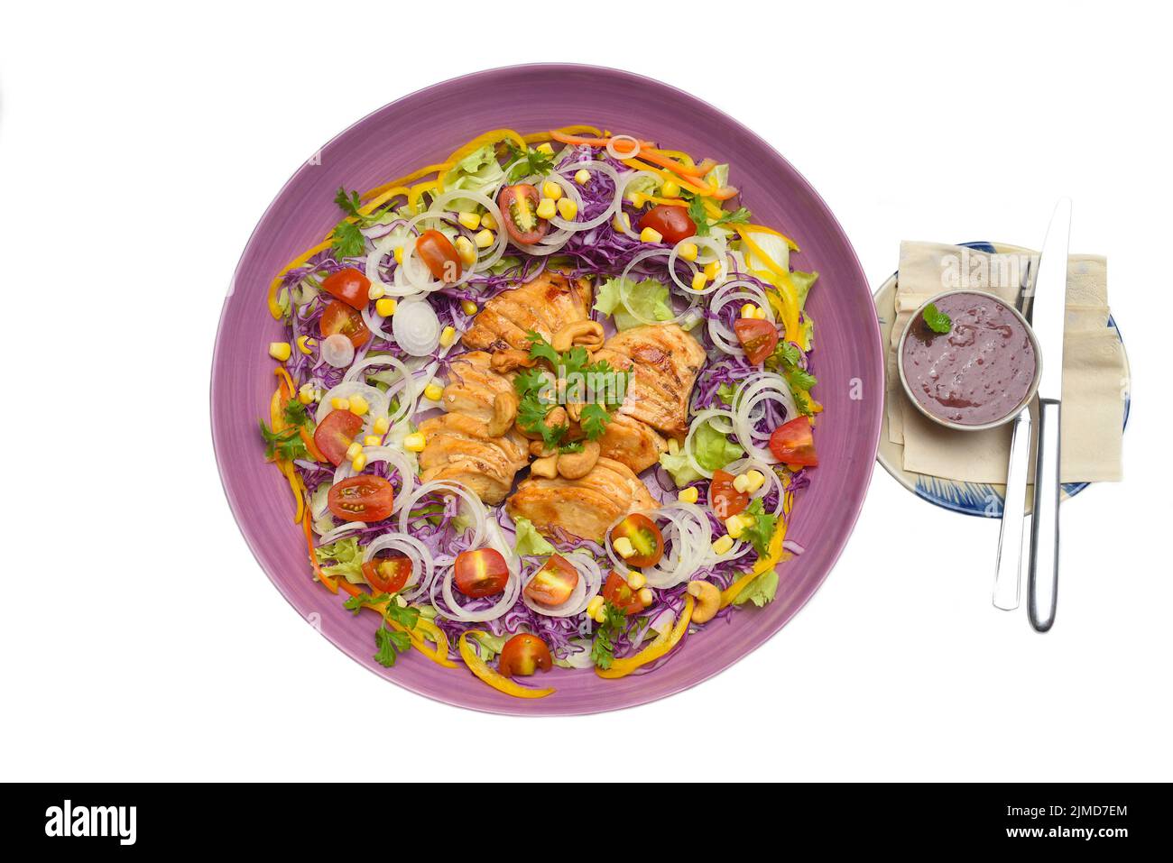 Pan fried chicken on a purple plate with greens and mulberry sauce on ...