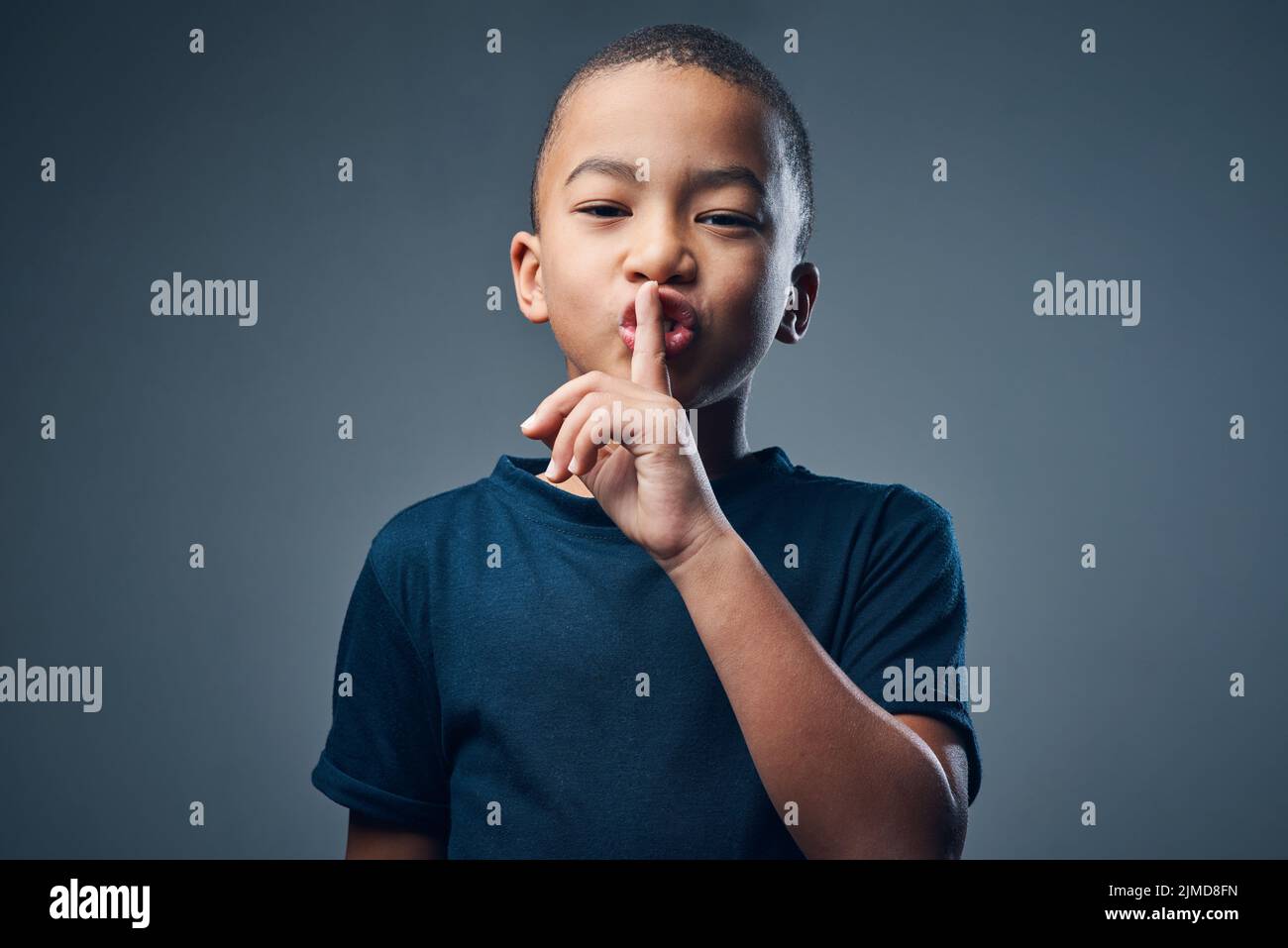 Dont tell mom... Studio shot of a cute little boy posing with his ...