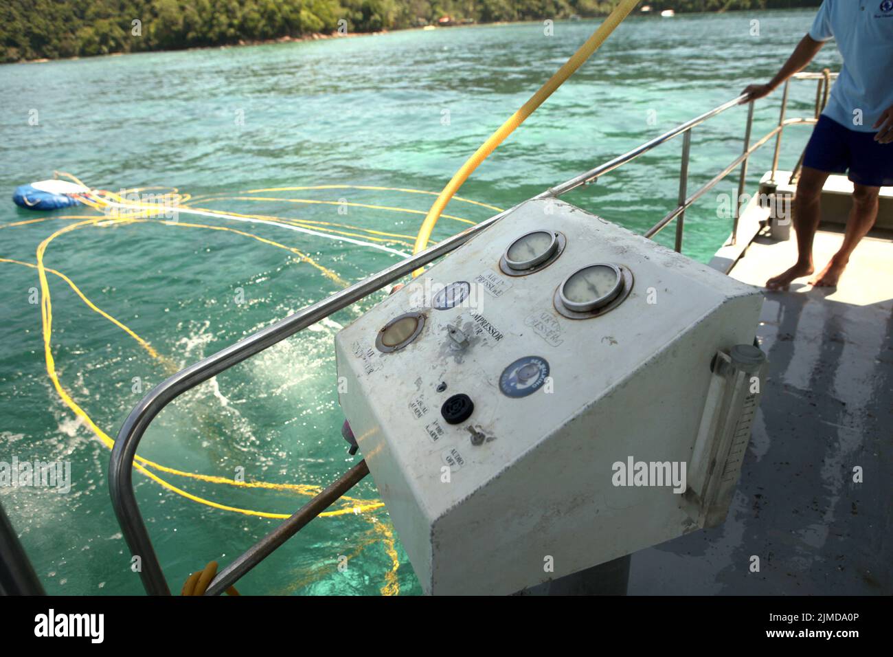 A marine tourism guide standing near equipment during a sea walking ...