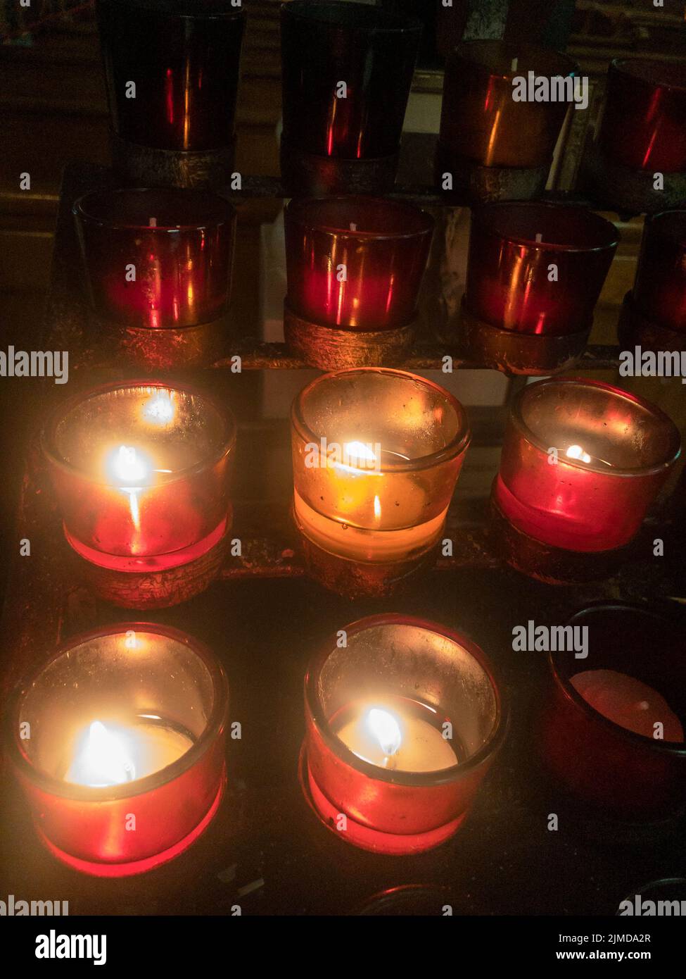 Red memorial votive candles flicker in a Catholic church Stock Photo ...