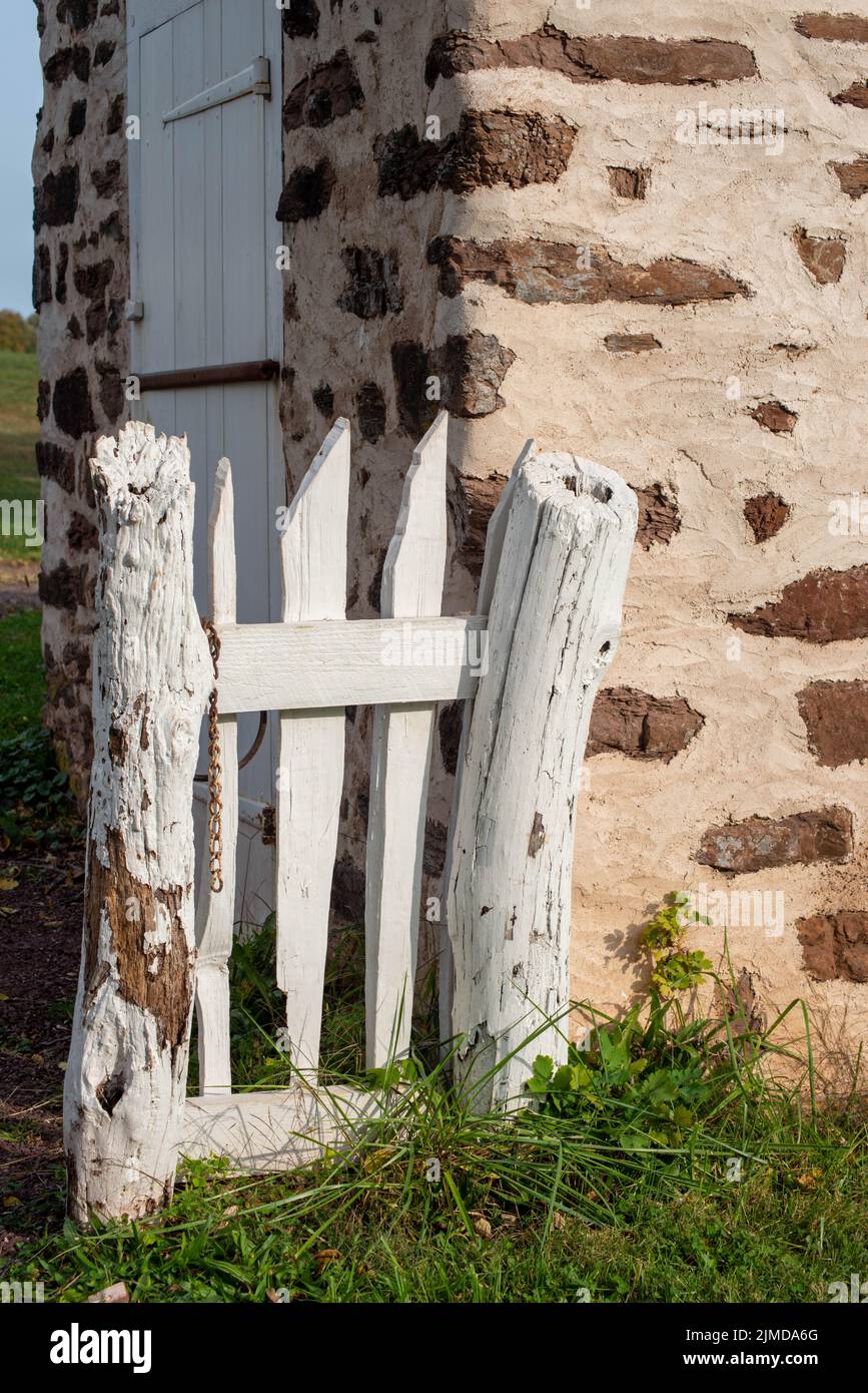 Rustic story book white garden gate by colonial American stone house ...