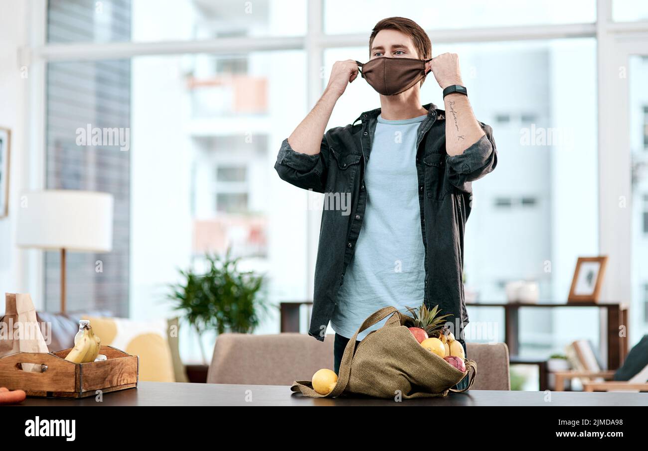 Safety before anything else. a young man putting on a mask before ...