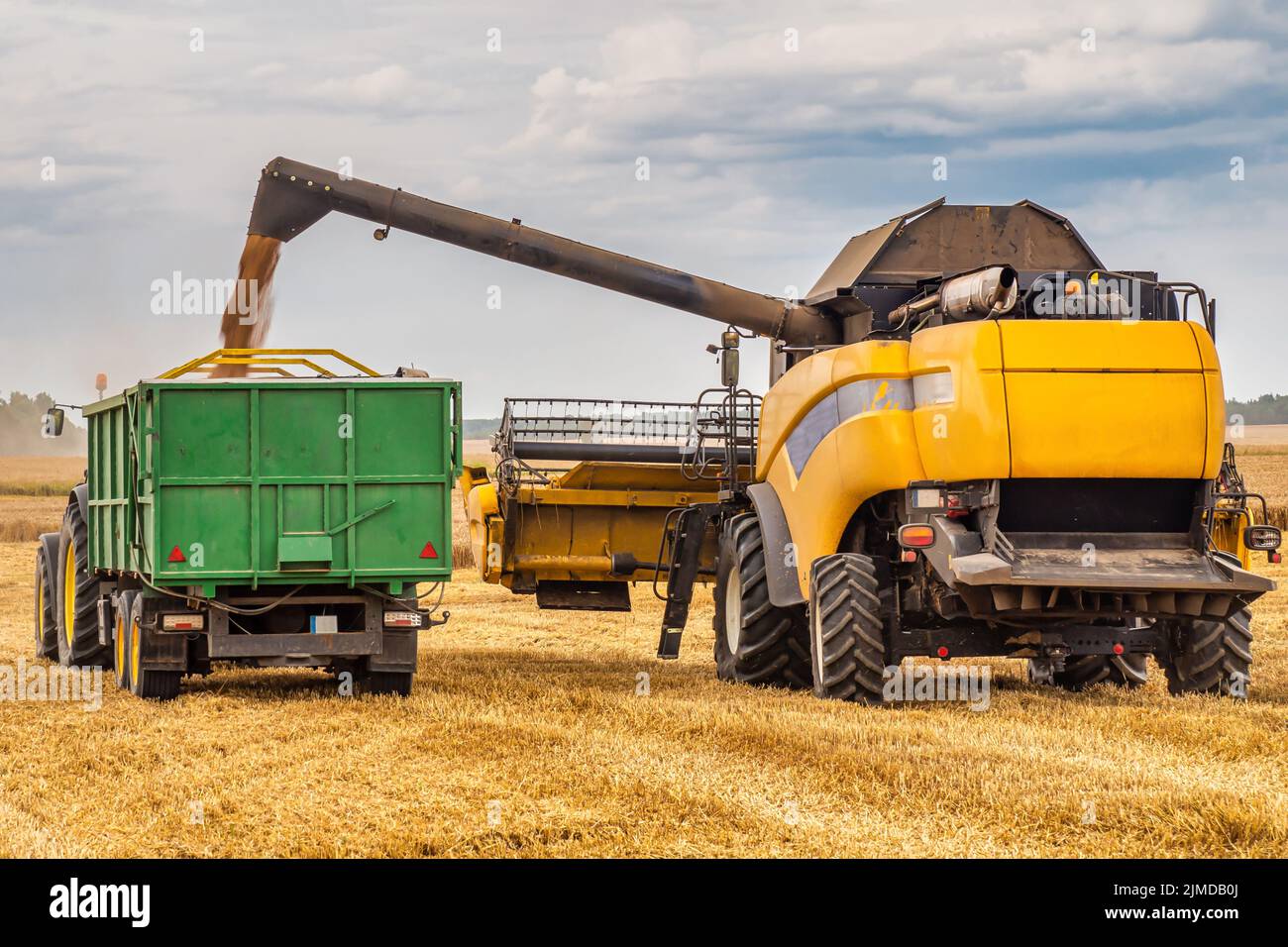 Harvester Combine and Tractor Working on The Large Wheat Field Stock ...