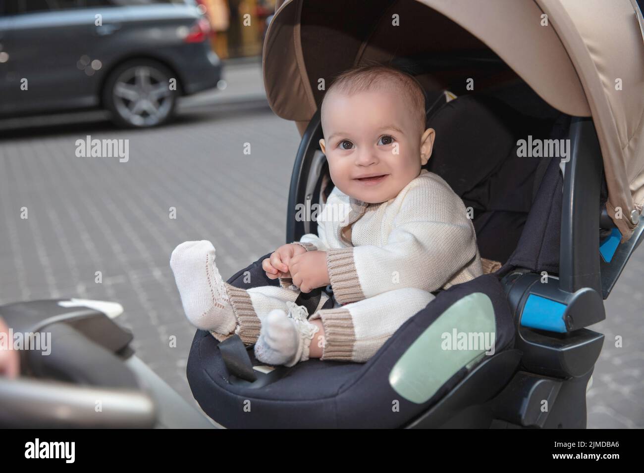 Funny little baby sitting in a stroller Stock Photo - Alamy