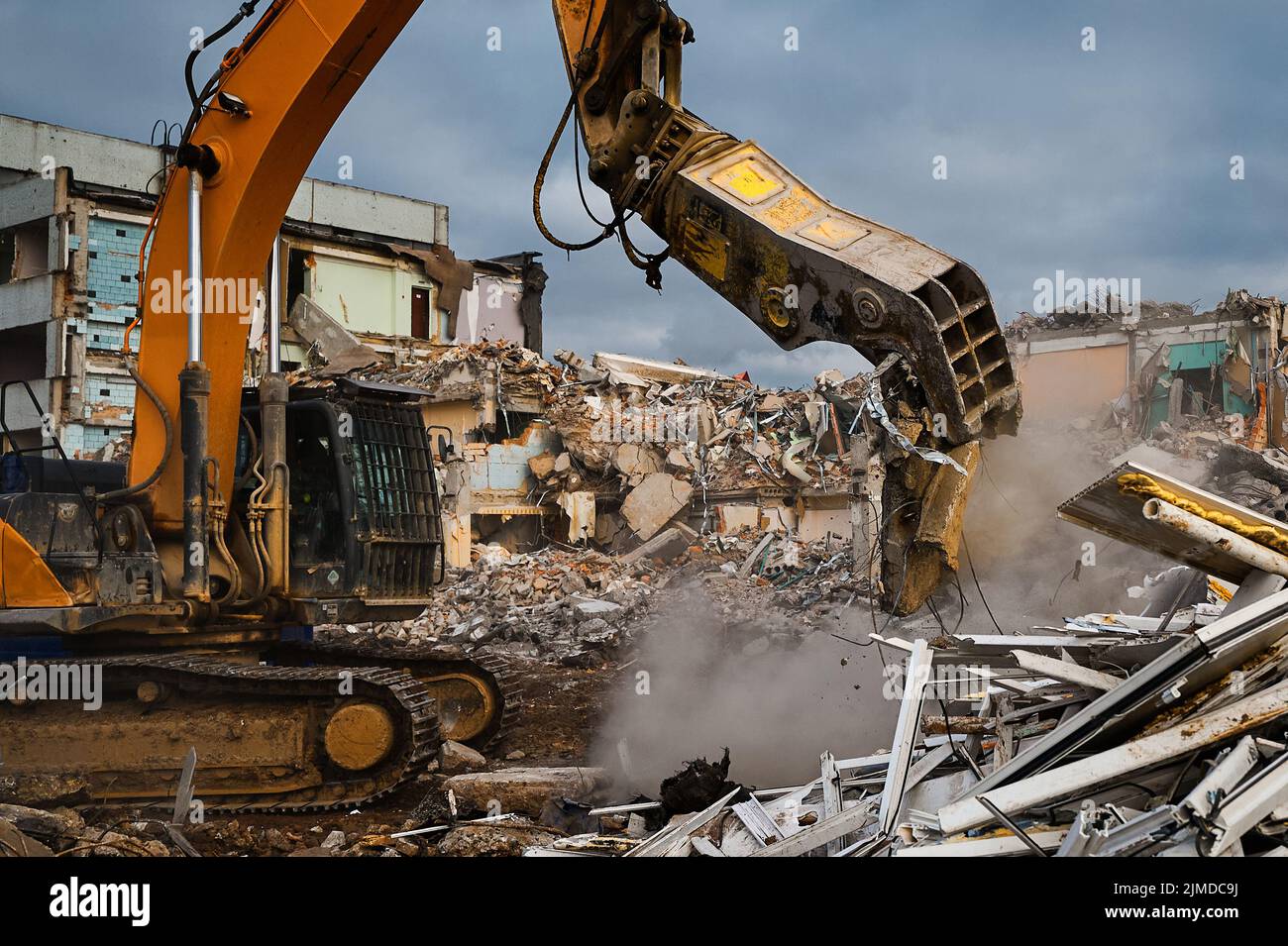 Excavator with hydraulic press breaks concrete leftovers Stock Photo - Alamy