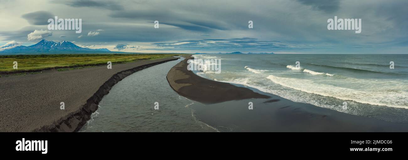 Beach with black sand and volcano Stock Photo - Alamy
