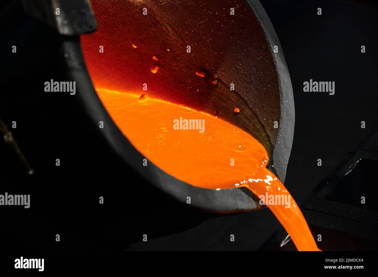 Pouring red liquid silver from bucket in induction oven Stock Photo - Alamy
