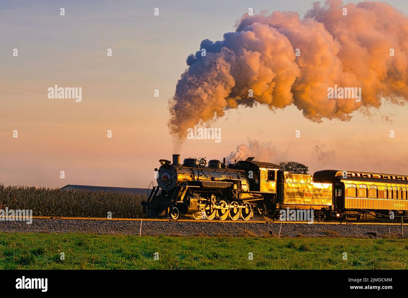 View of Golden Steam Passenger Train at Sunrise Stock Photo - Alamy