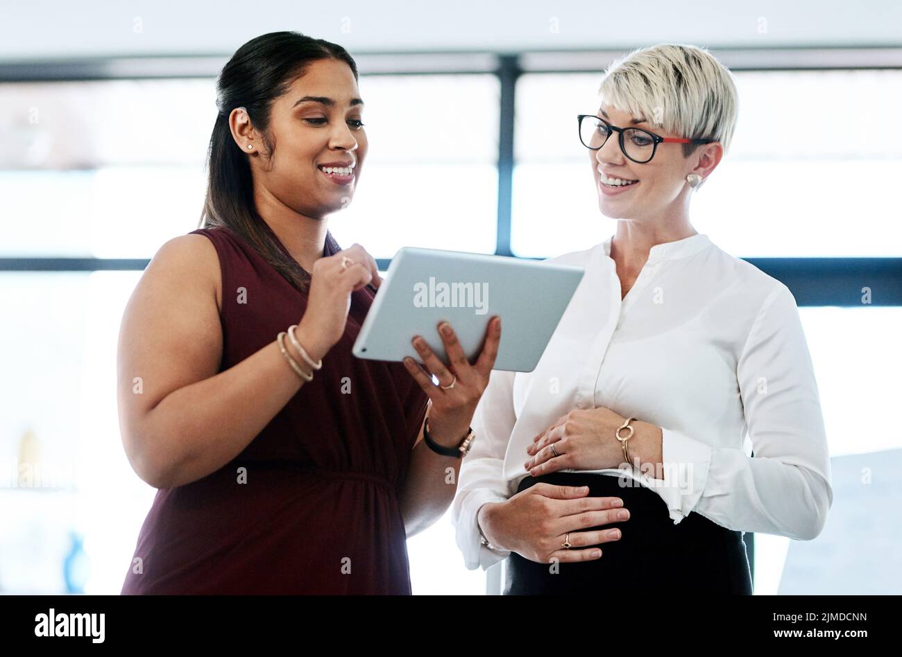 Working together to attain their goals. two businesswomen using a ...