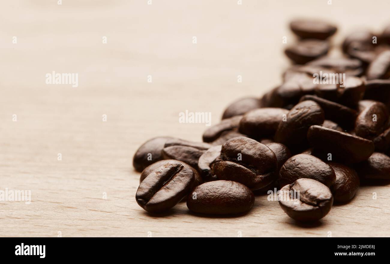 Life is hard, coffee helps. Still life shot of coffee beans on a wooden ...