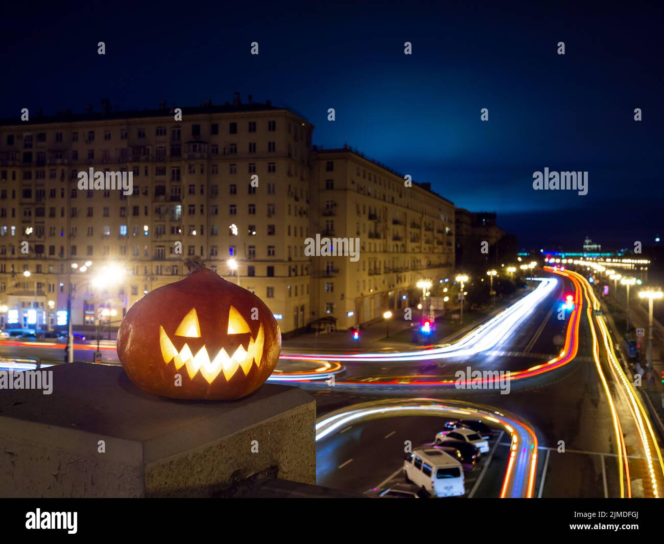 Halloween pumpkin on the background of the night city. Buildings and ...