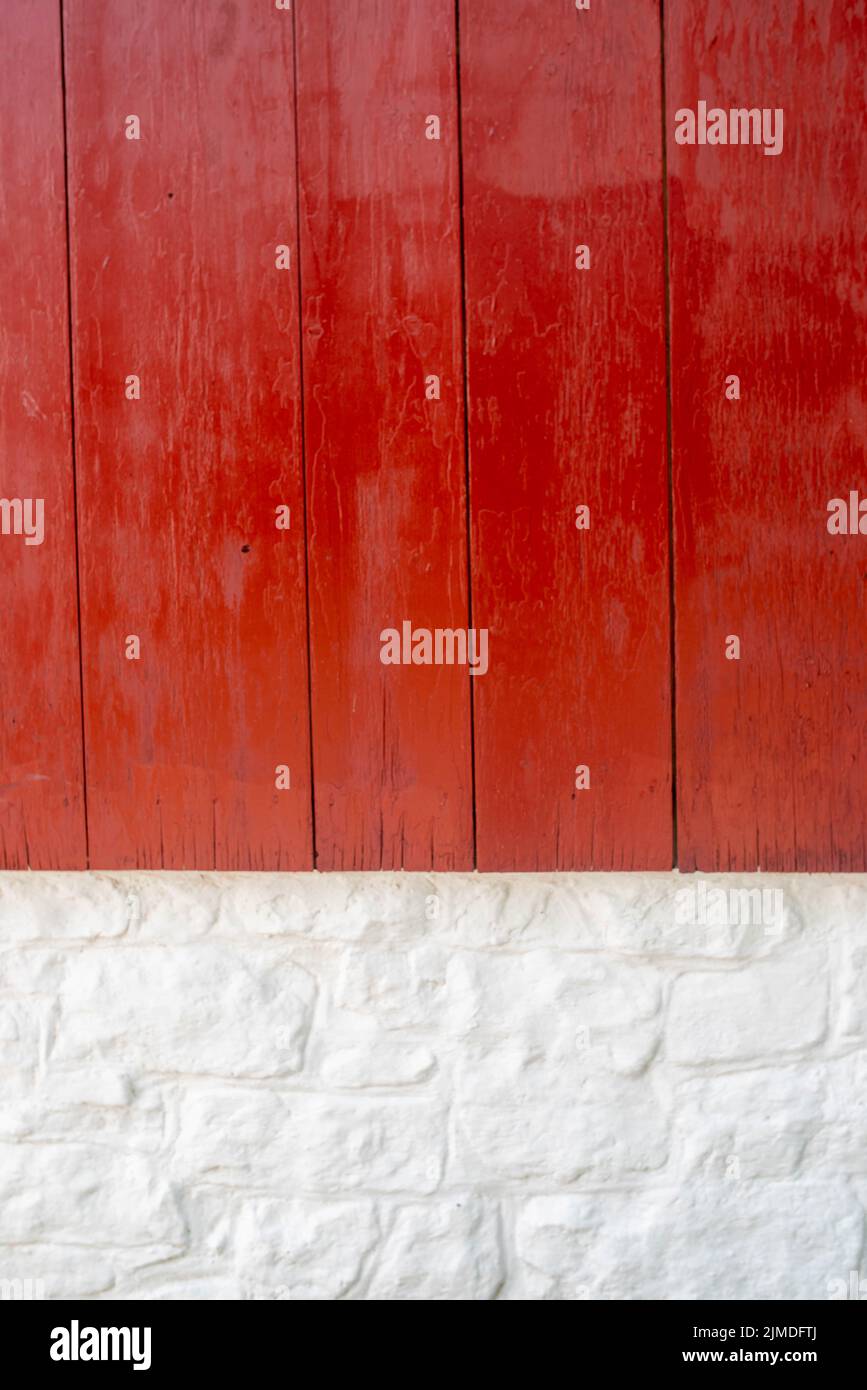 Vertical bright red wood and whitewashed stone exterior wall close up ...