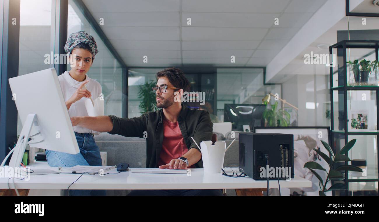 Taking care of things in the office. two young businesspeople working ...