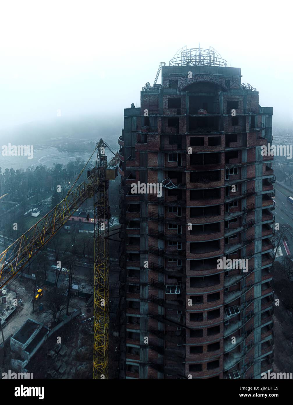 Large abandoned unfinished brick building skyscraper and big yellow ...