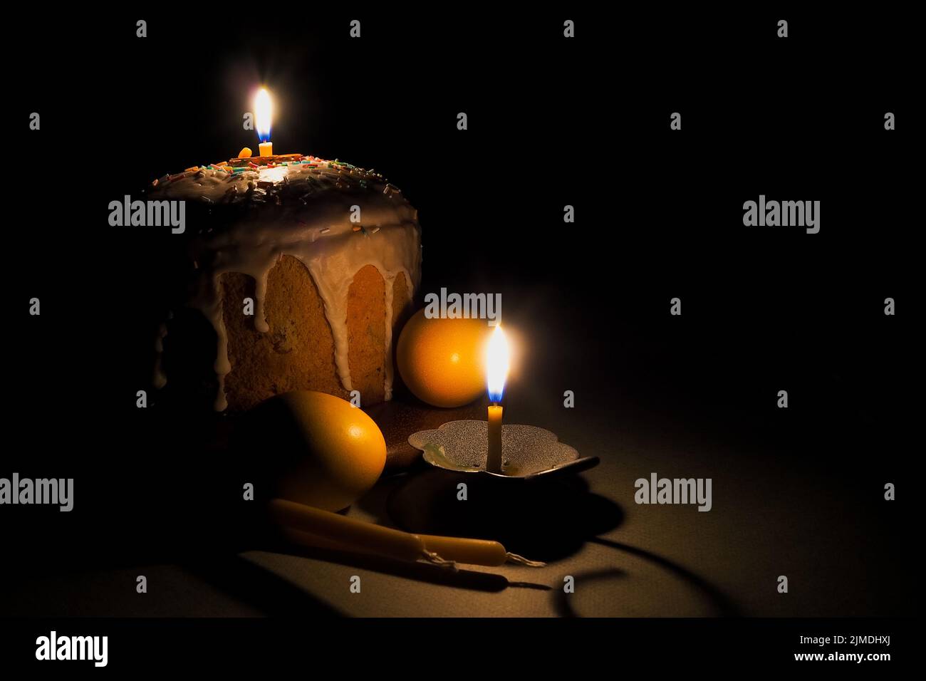 Easter cake, easter eggs and burning church candles in the dark Stock ...