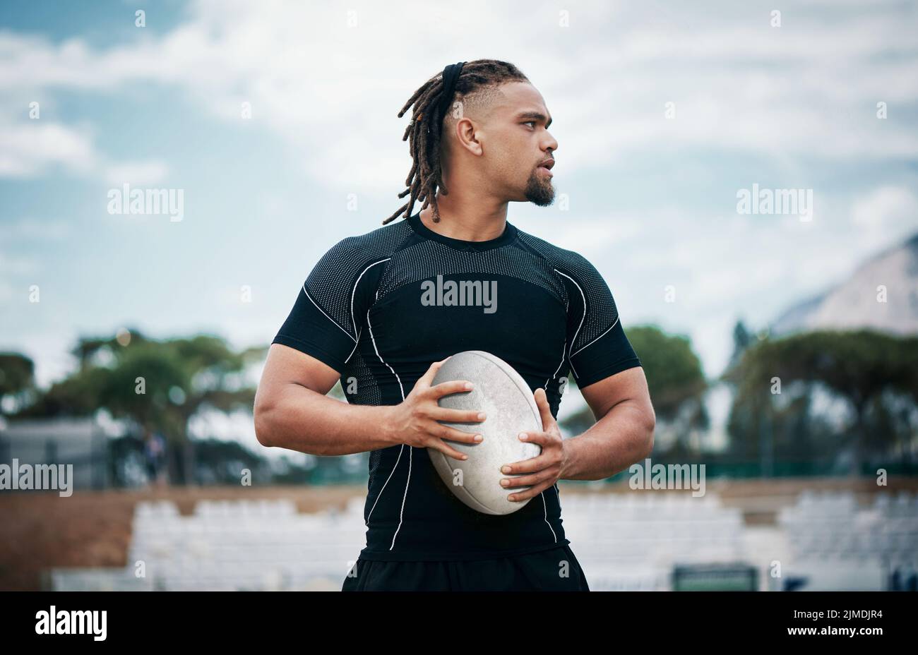 Rugby is his profession. a handsome young rugby player holding a rugby ...