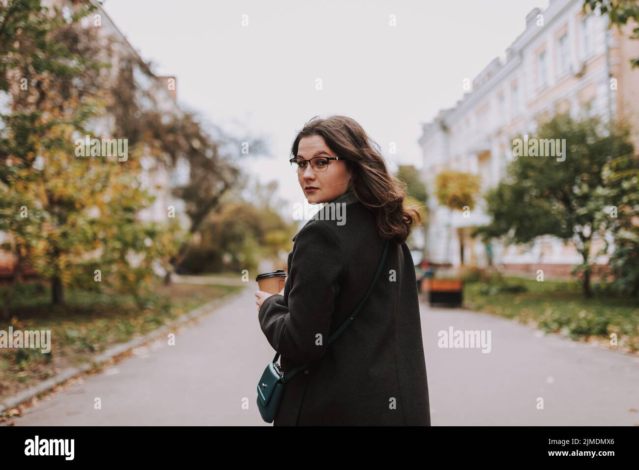 Beautiful lady walking in the city and turning back Stock Photo - Alamy