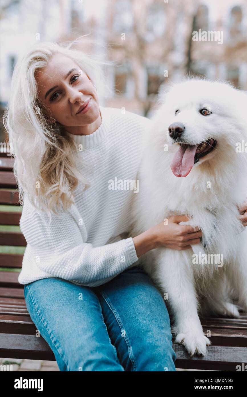 Happy pretty female embracing her samoyed dog Stock Photo - Alamy