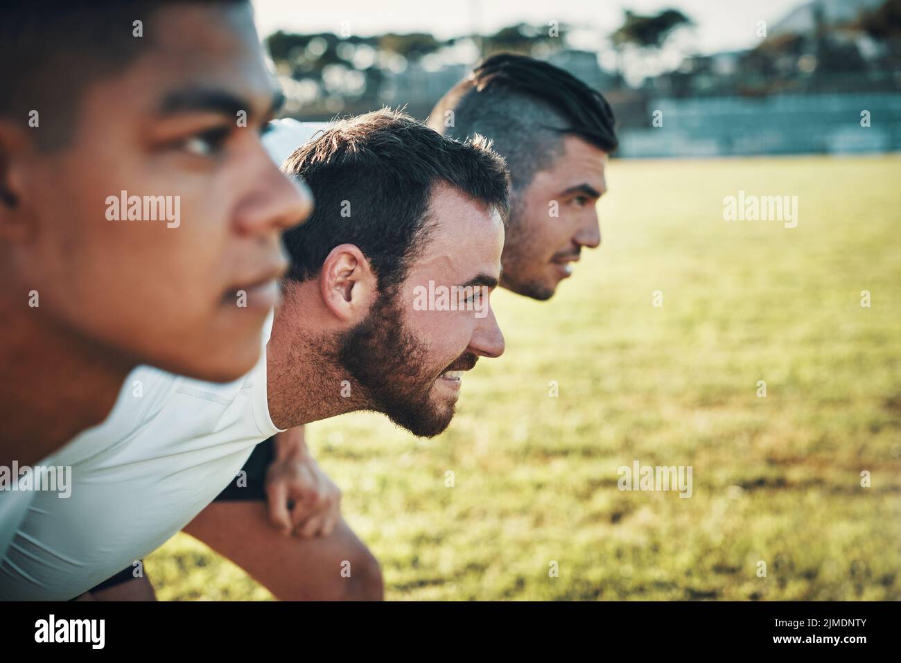 Winning is their goal. a group of three young rugby players lining up ...
