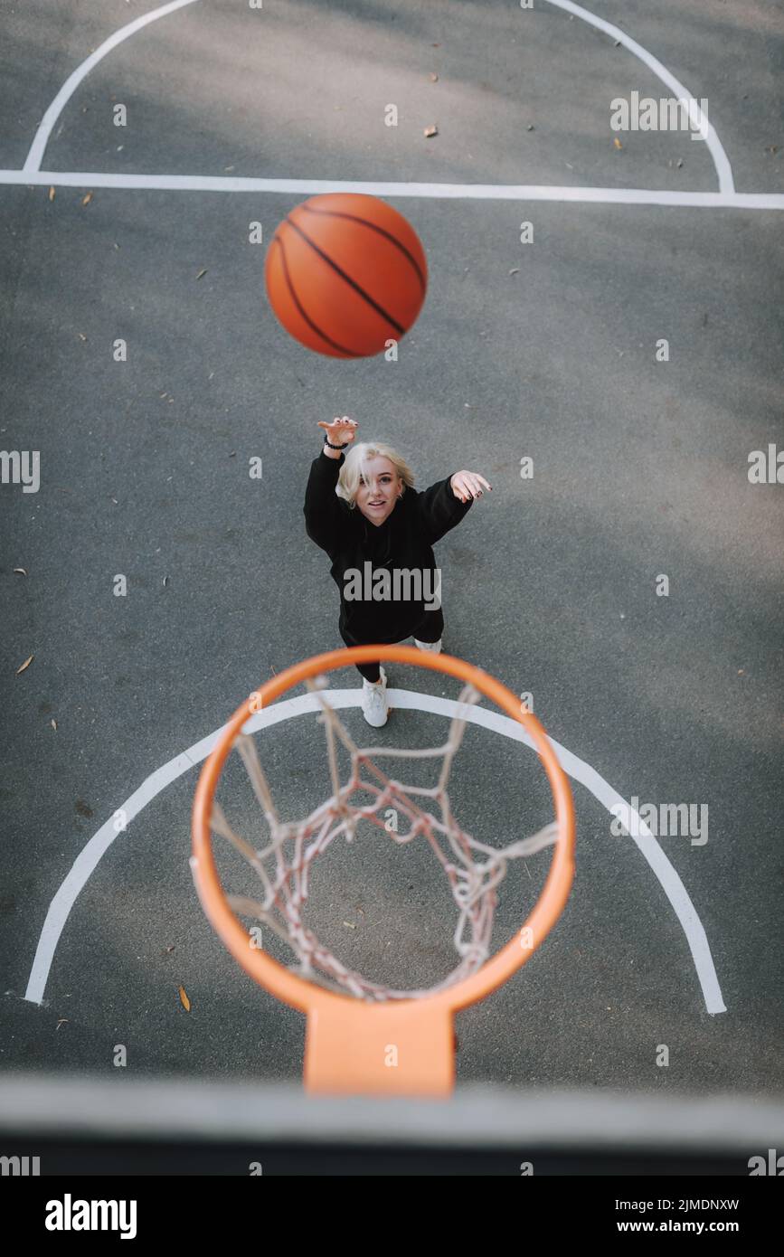 Happy pretty lady throwing ball into the basket Stock Photo - Alamy