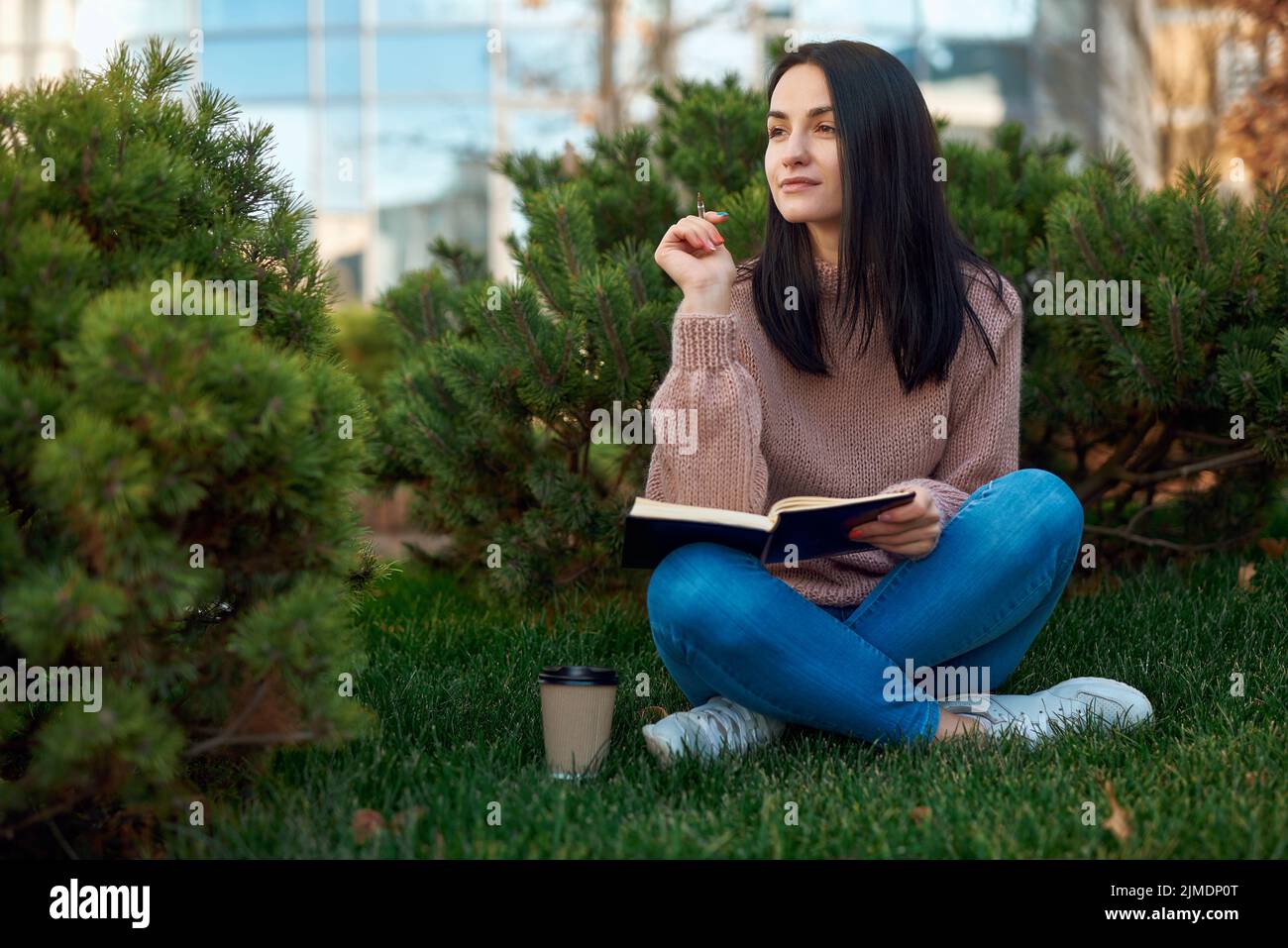 Pretty young lady studying outdoors in the park Stock Photo - Alamy