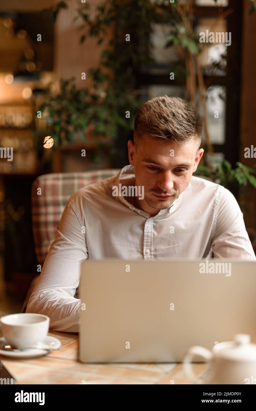 Young man using computer in coffee shop Stock Photo - Alamy