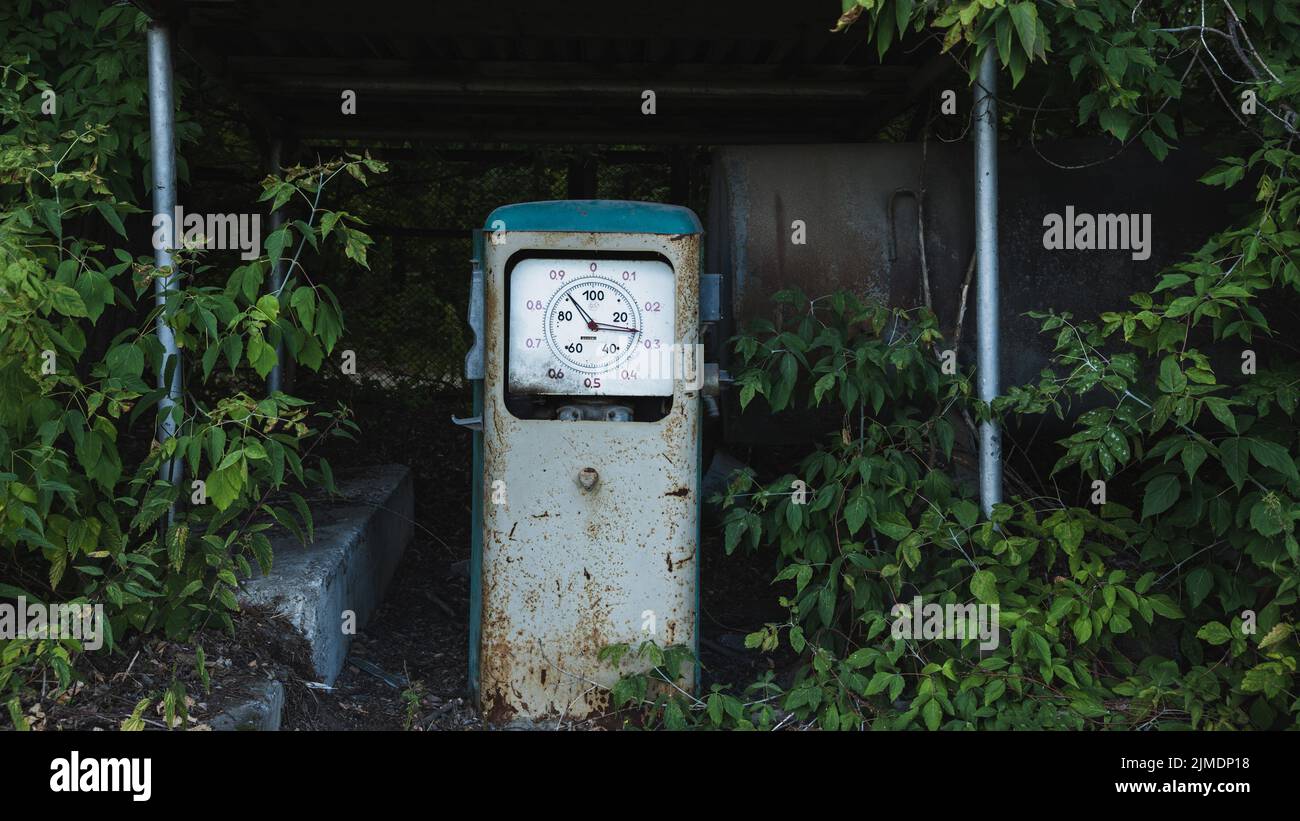Old rusty abandoned gas station overgrown with grass and trees Stock ...