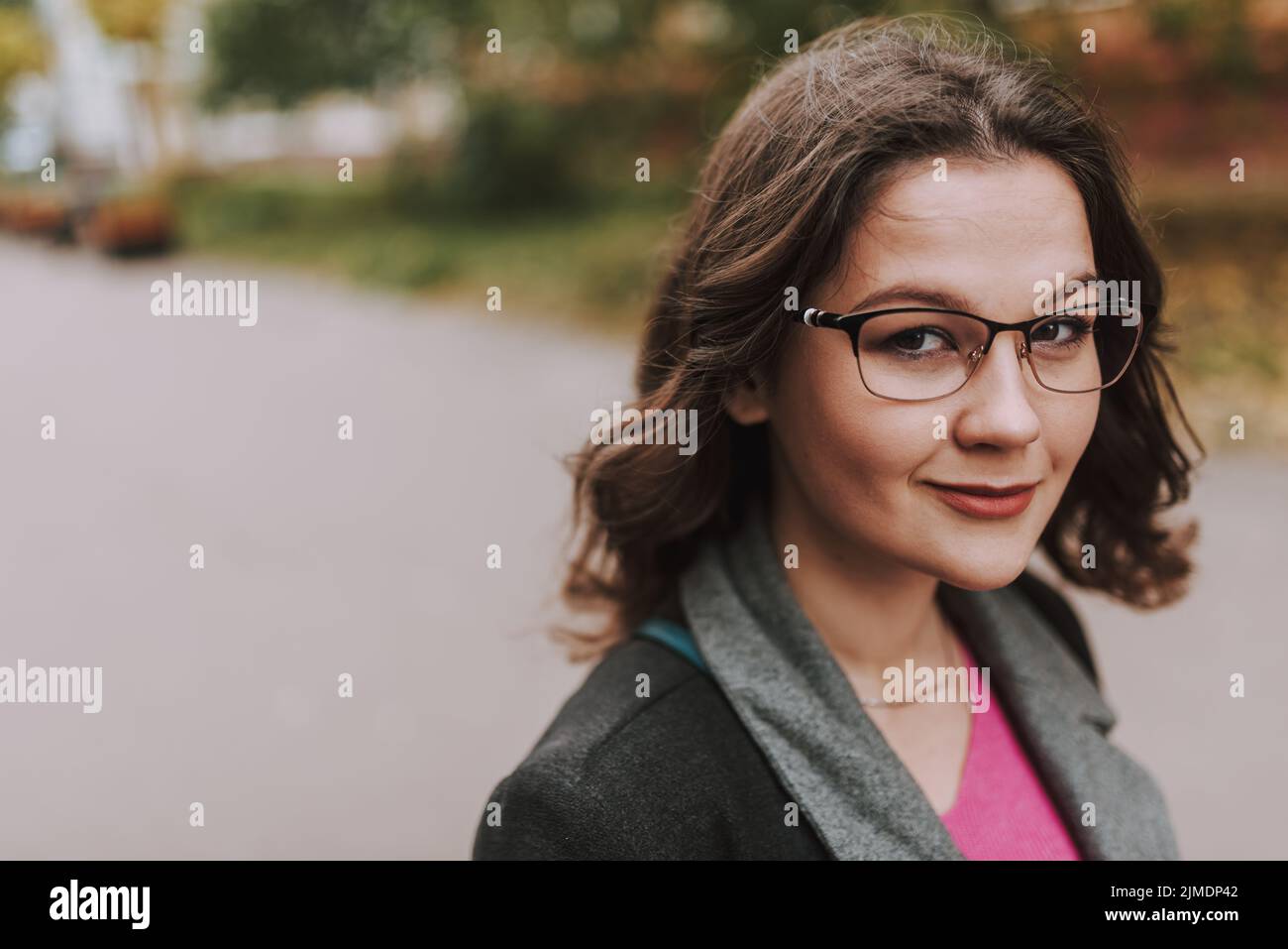 Kind smile of attractive young lady in the street Stock Photo - Alamy