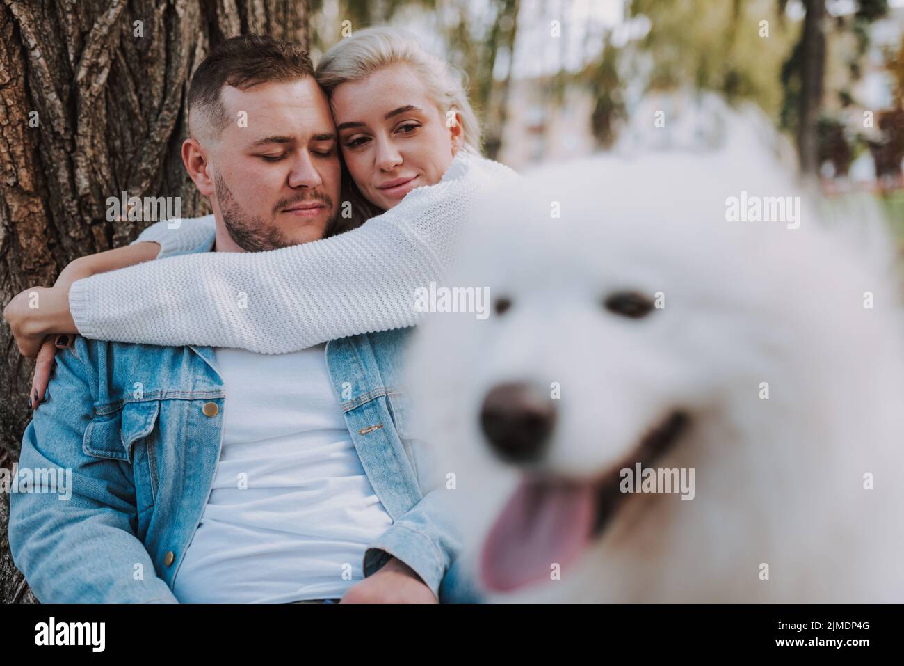Young people are relaxing outdoors with their cute puppy Stock Photo ...
