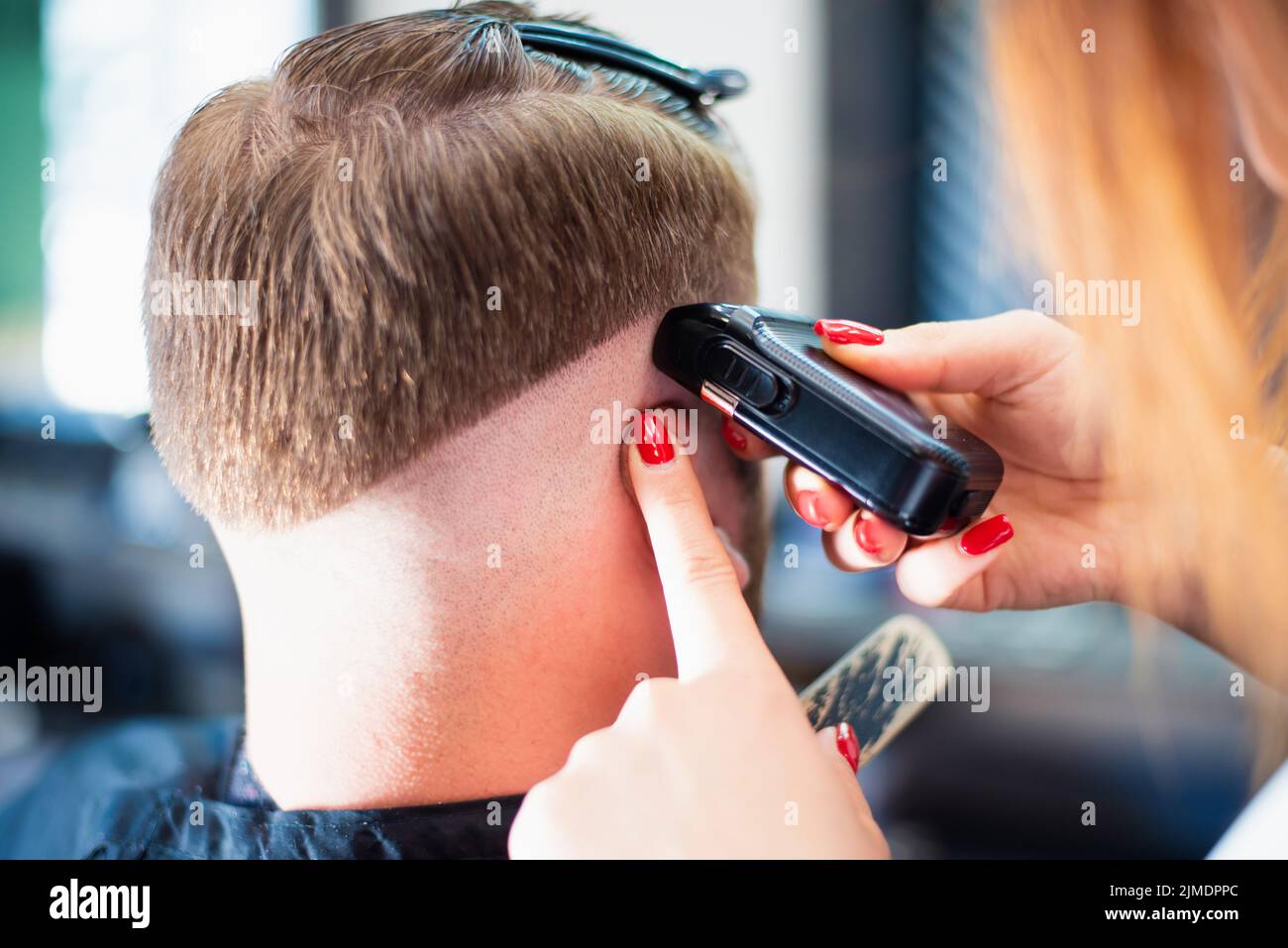 Beautiful hairdresser woman cutting a man's hair in a barbershop Stock ...