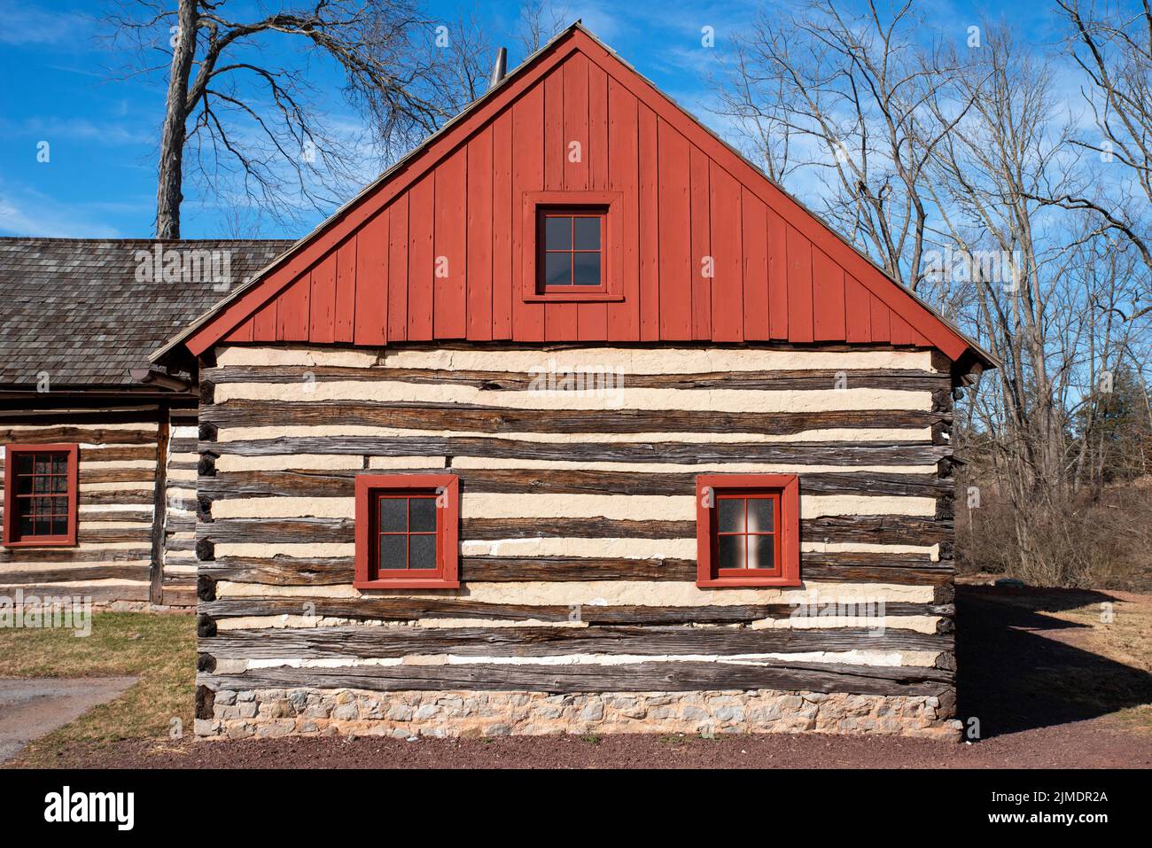 Red peaked roof and log construction of a colonial house Stock Photo ...
