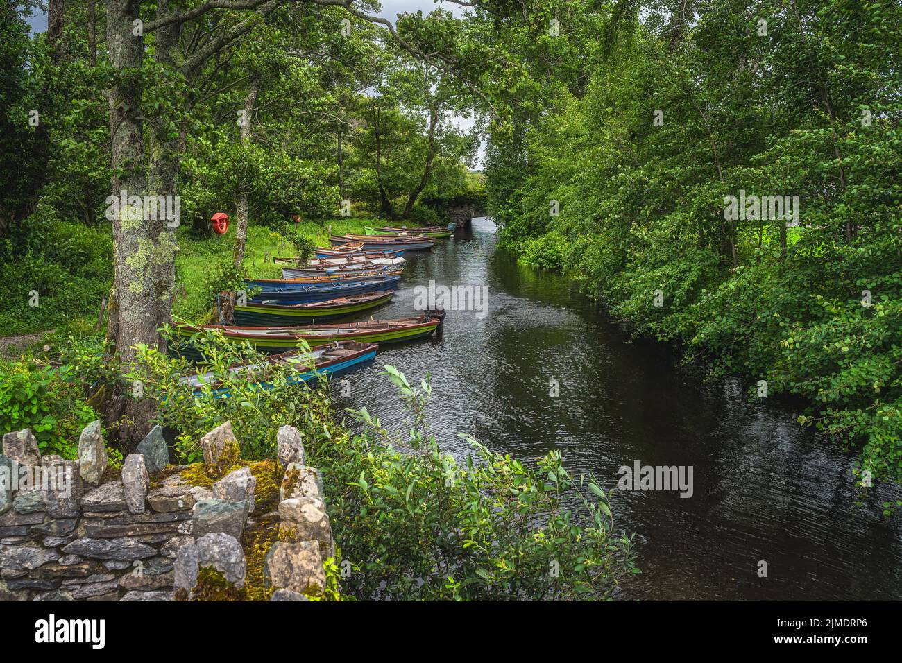 Small old wooden paddle boats moored in a row on narrow canal Stock ...