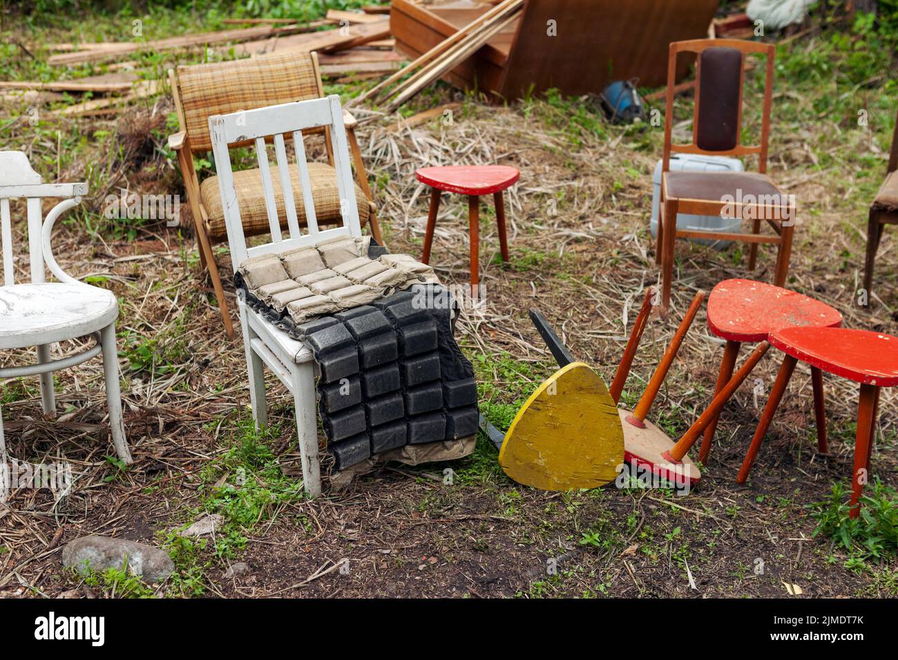 a group of tabourets and chairs placed in a messy backyard, daylight ...