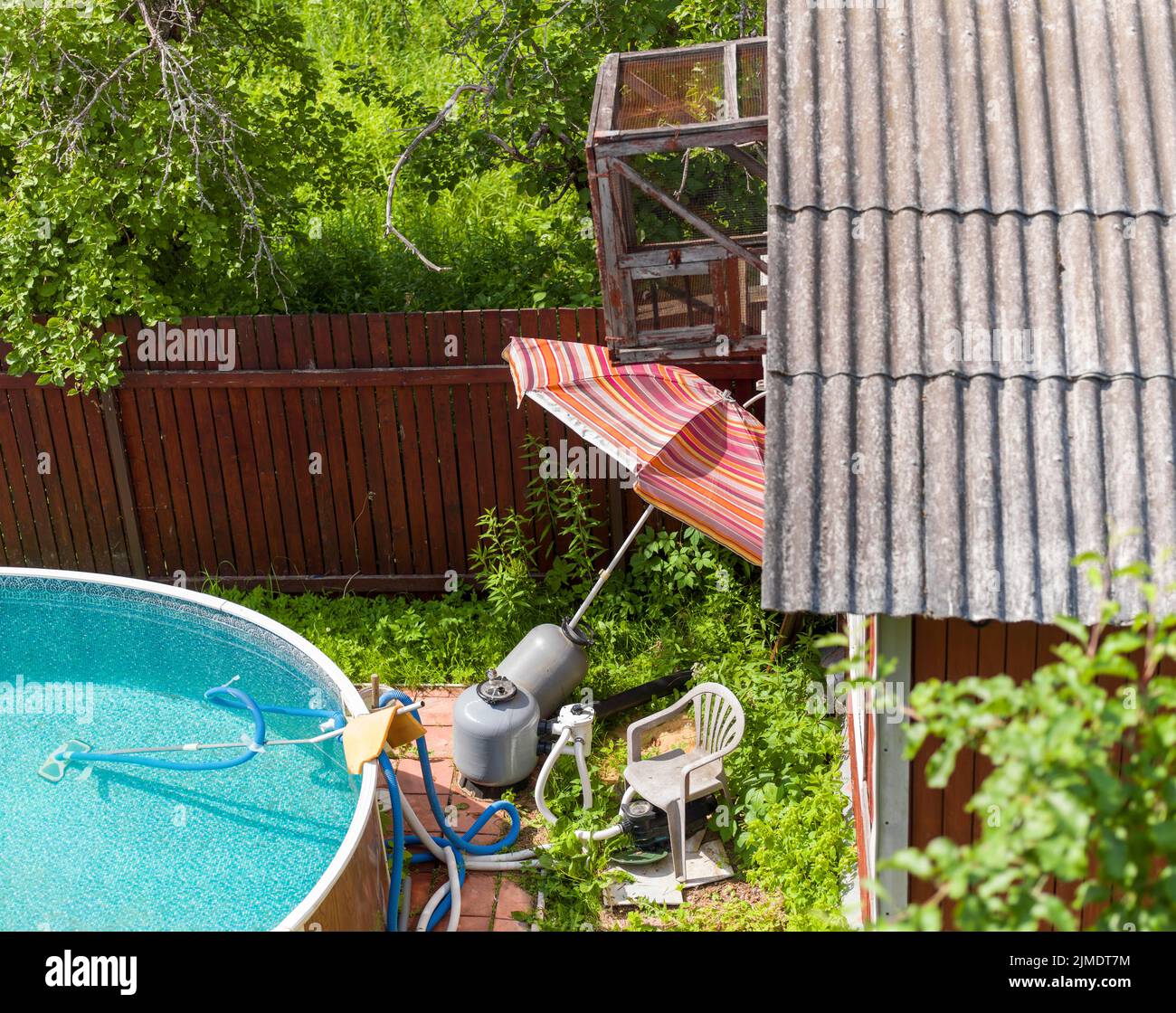 damaged sun umbrella next to outdoor above ground swimming pool Stock ...